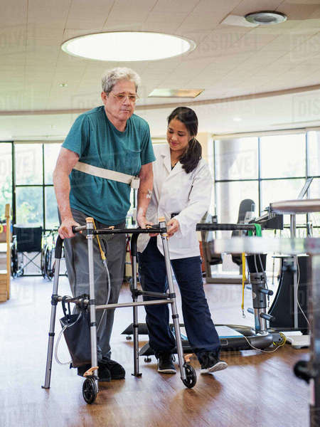 Physical therapist helping man using walker - Royalty-free Stock Photo ...