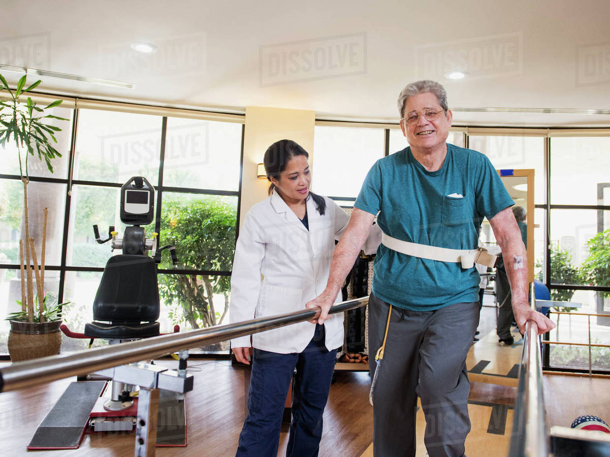 Physical therapist helping walking man - Royalty-free Stock Photo ...