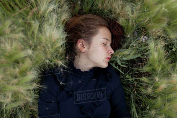 Caucasian girl laying in field - Royalty-free Stock Photo | Dissolve