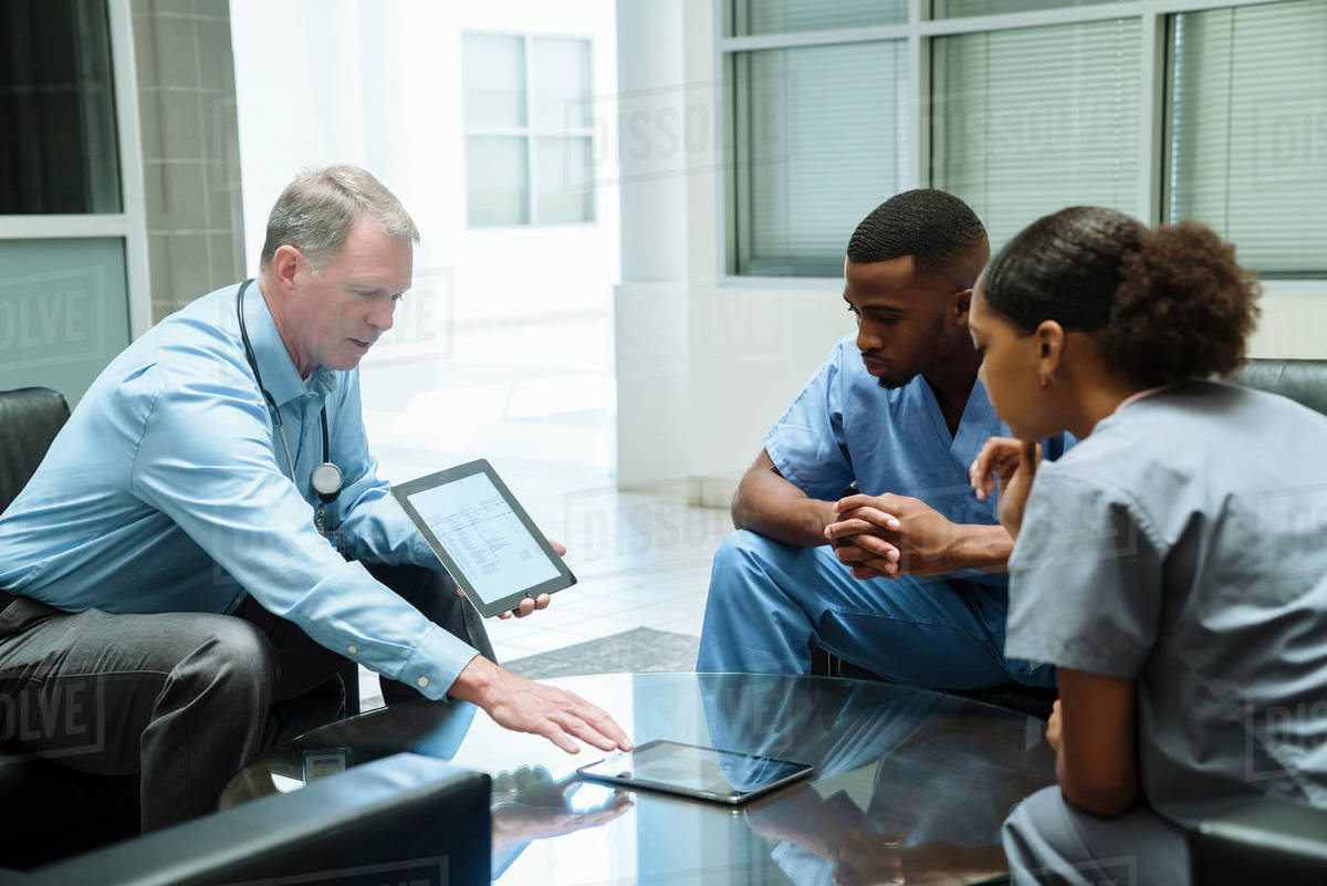 Doctor and nurses discussing digital tablet - Stock Photo - Dissolve