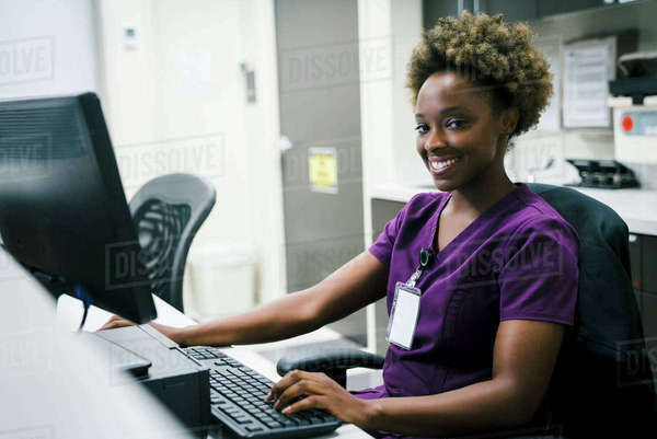Portrait of smiling black nurse using computer - Royalty-free Stock ...