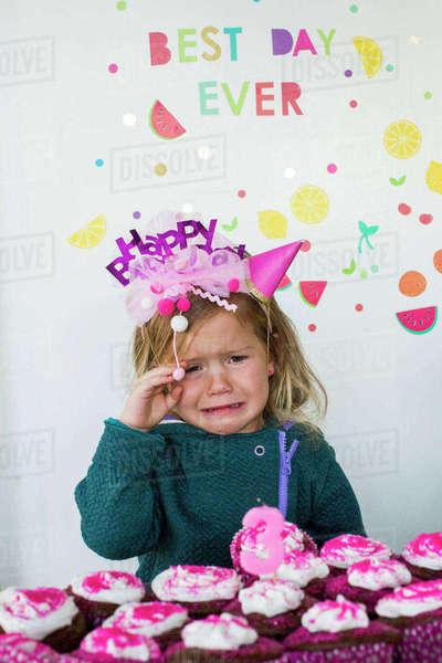 Caucasian girl crying over tray of cupcakes for birthday - Royalty-free ...
