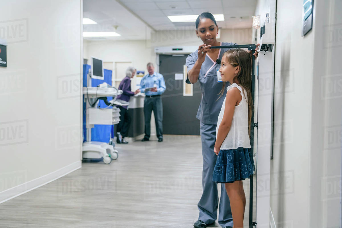 Nurse measuring height of girl in hospital - Royalty-free Stock Photo ...