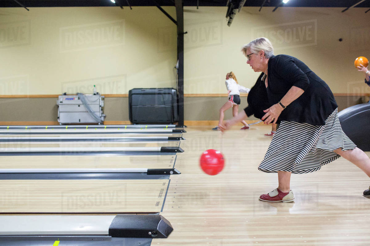 Caucasian woman releasing bowling ball in lane - Royalty-free Stock ...
