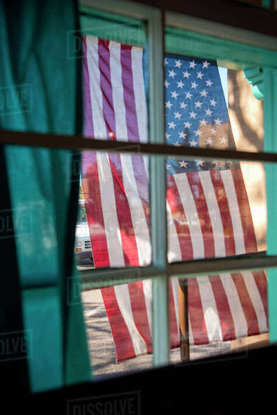 American flag hanging outside window - Stock Photo - Dissolve