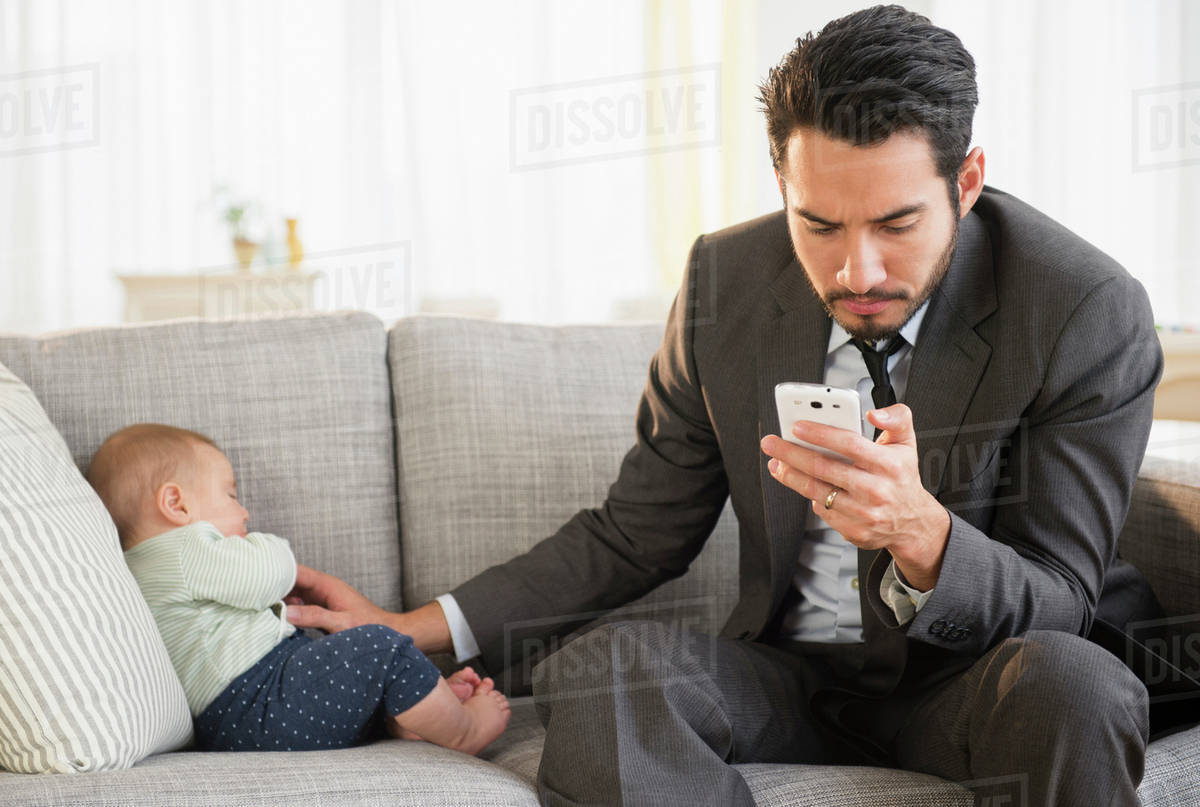 Father sitting with baby and using cell phone - Royalty-free Stock ...