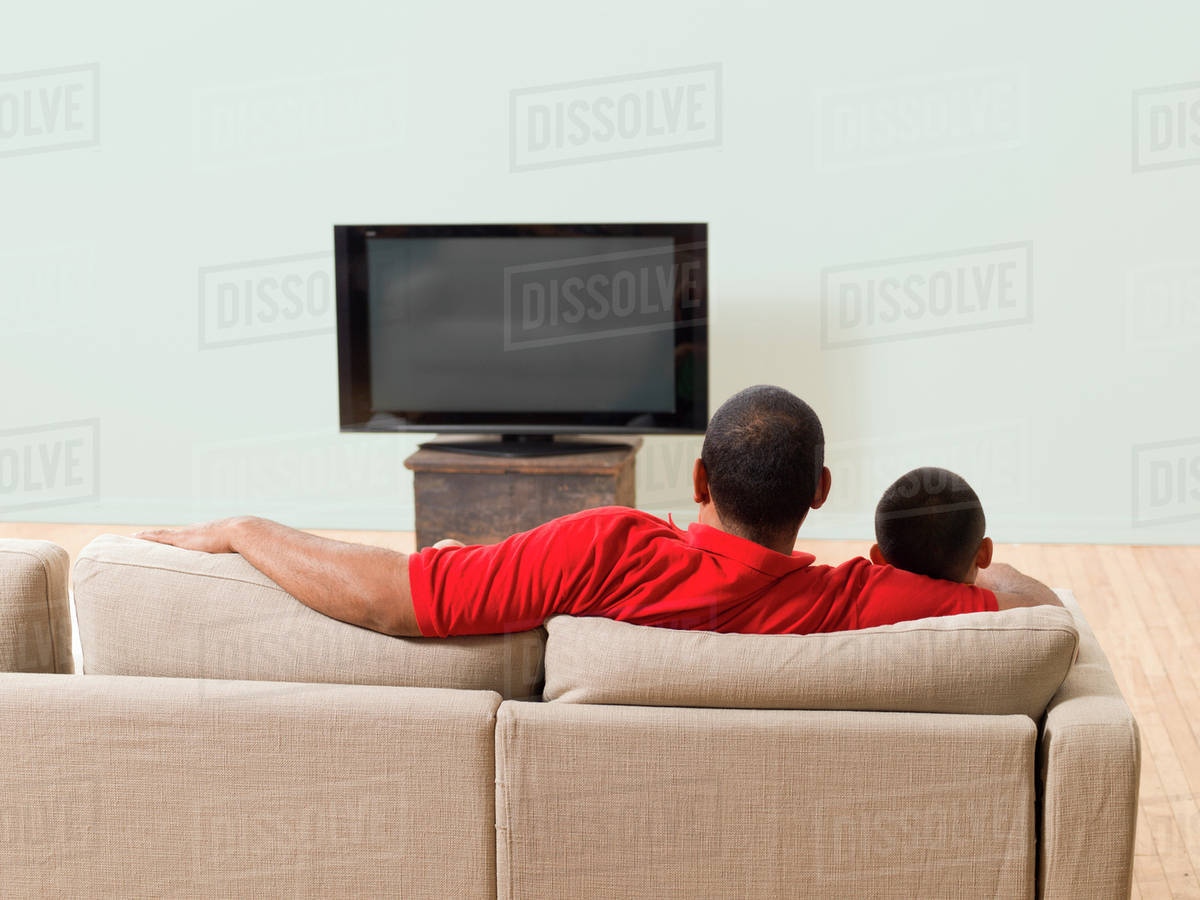 Father and son watching television in living room - Royalty-free Stock ...