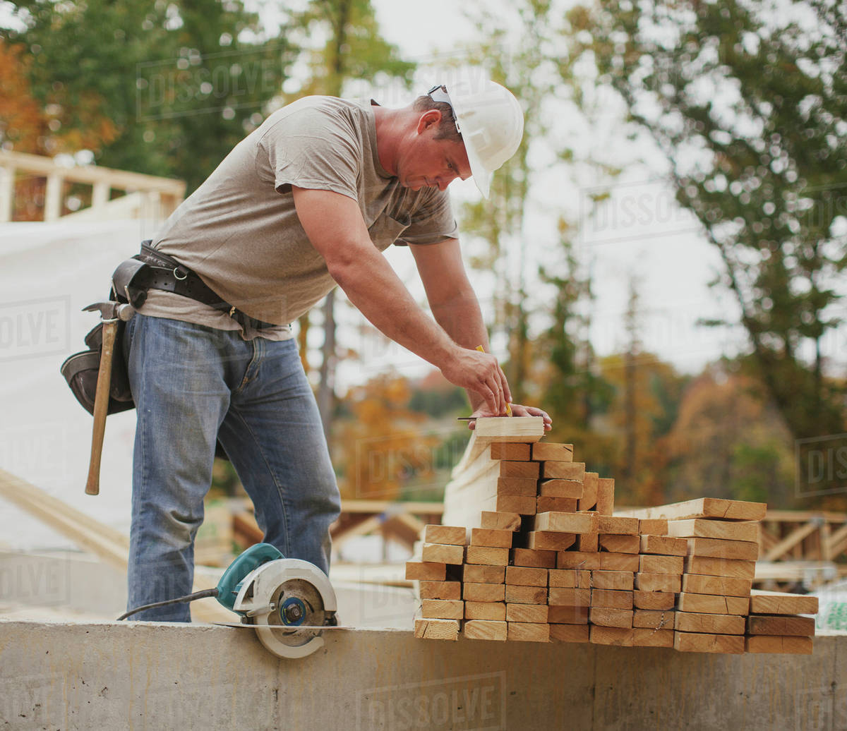 Caucasian construction worker marking wood planks - Royalty-free Stock ...