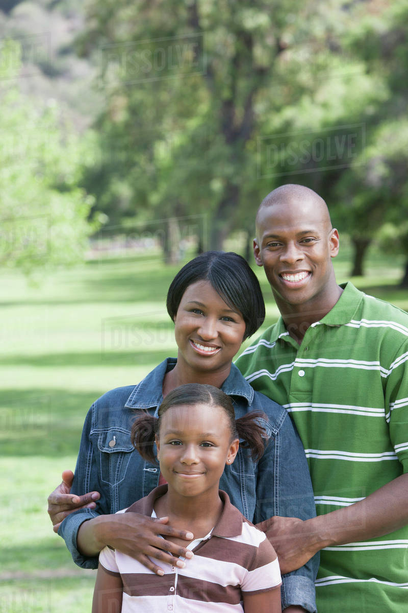 Family smiling together in park - Royalty-free Stock Photo | Dissolve