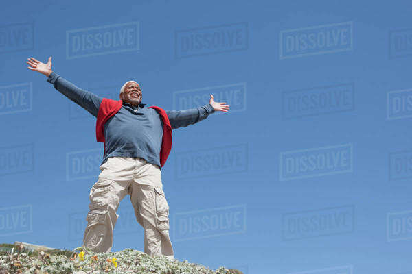 Mixed race Senior man cheering from cliff edge - Royalty-free Stock ...