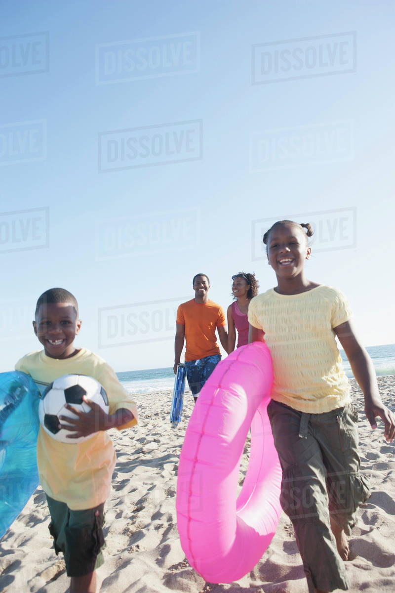 Children carrying inner tubes on beach - Royalty-free Stock Photo ...