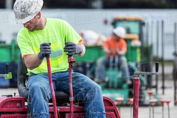 Worker operating machinery on construction site - Royalty-free Stock ...