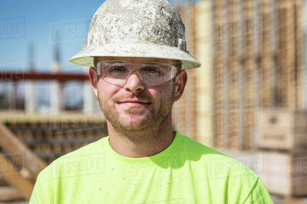 Worker smiling on construction site - Stock Photo - Dissolve
