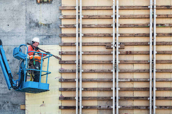 Caucasian worker on boom lift working on construction site - Royalty ...
