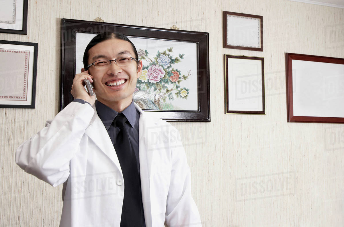 Mixed race doctor smiling in office - Royalty-free Stock Photo | Dissolve