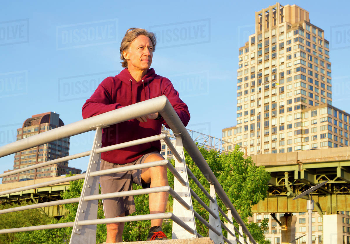Caucasian man leaning on railing in urban park - Stock Photo - Dissolve