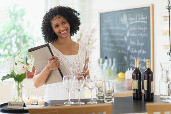 Mixed race hostess smiling in restaurant - Stock Photo - Dissolve