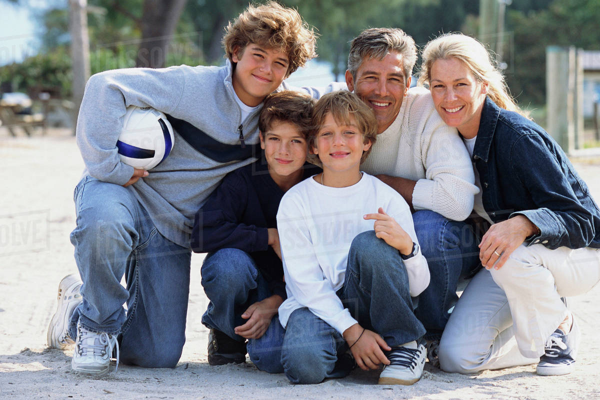 Family smiling together in park - Royalty-free Stock Photo | Dissolve