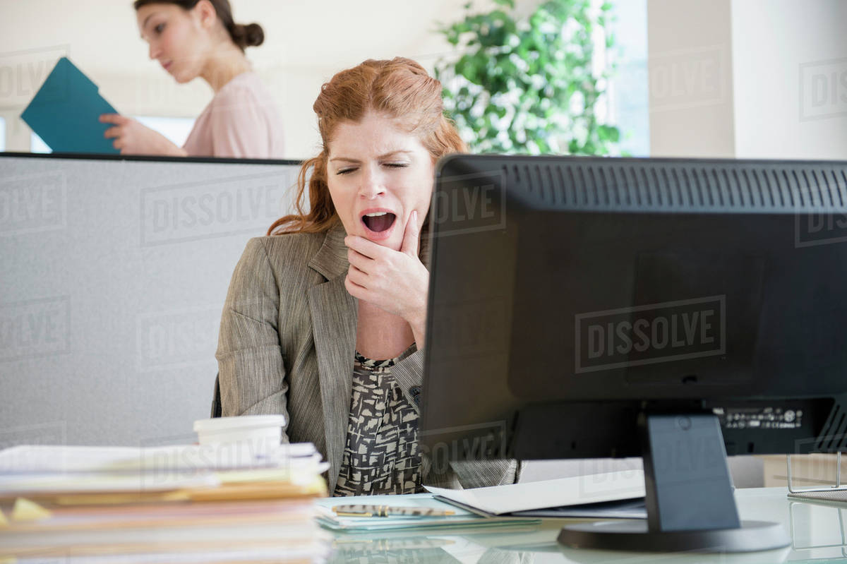 Caucasian businesswoman yawning at desk - Royalty-free Stock Photo ...