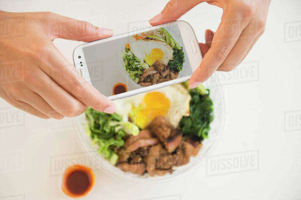 Close up of mixed race man photographing food with cell phone - Stock ...