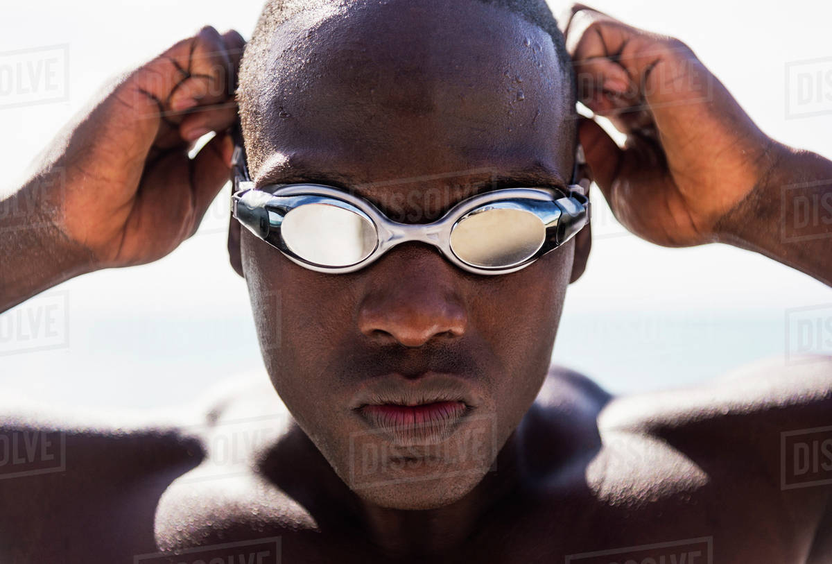 Mixed race swimmer putting on goggles - Stock Photo - Dissolve