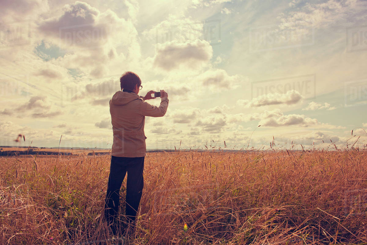 Mari man photographing rural field with cell phone - Royalty-free Stock ...