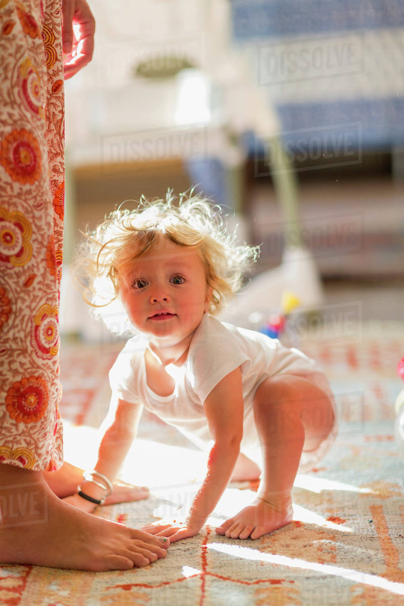 Caucasian baby boy crouching by feet of mother - Royalty-free Stock ...