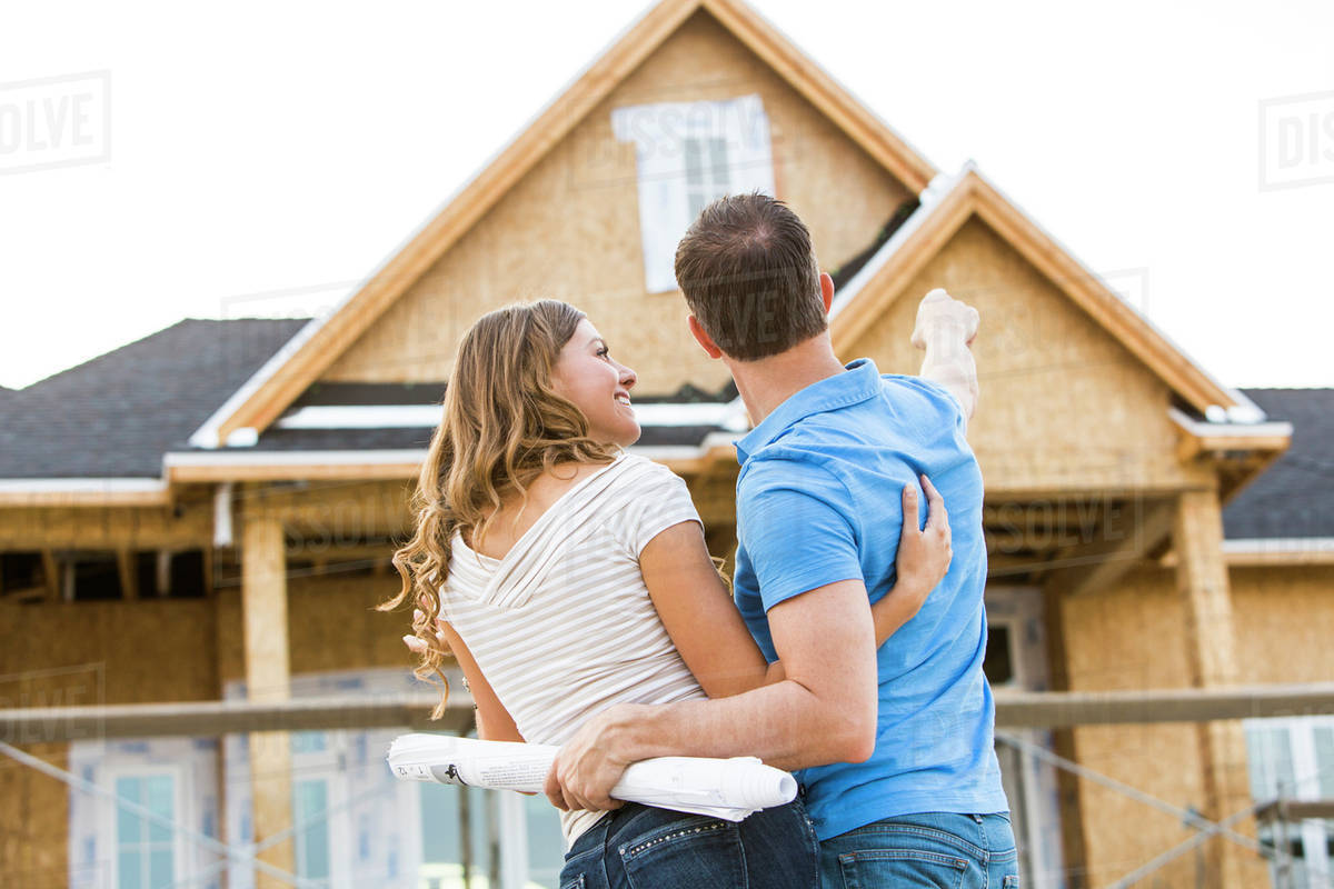Caucasian couple admiring house under construction - Royalty-free Stock ...