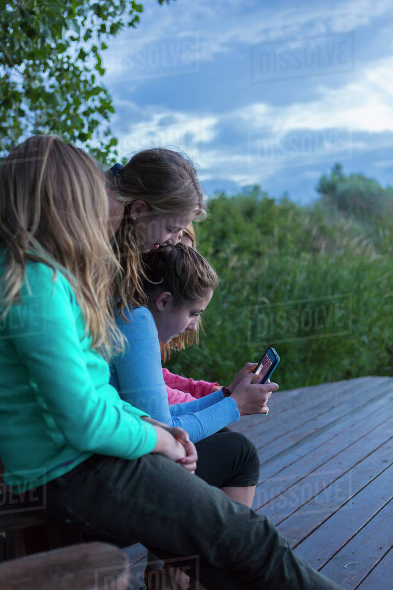 Children using cell phone together outdoors - Royalty-free Stock Photo ...