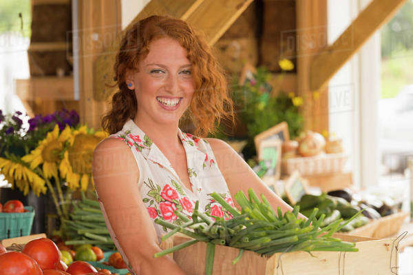 Caucasian woman carrying produce at farmers market - Stock Photo - Dissolve