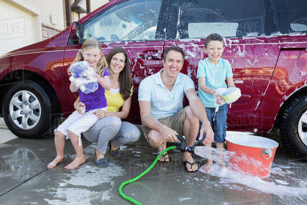 Caucasian family washing car in driveway - Royalty-free Stock Photo ...