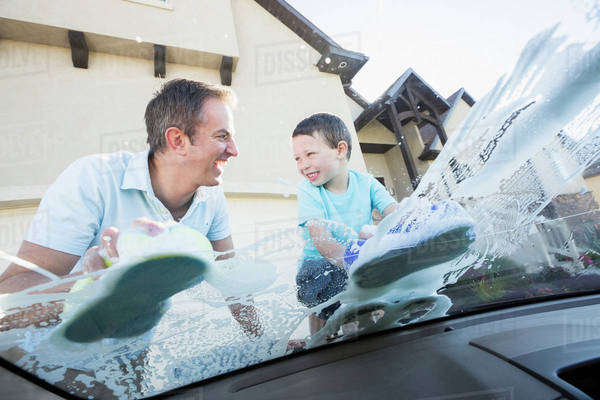 Caucasian father and son washing car windshield - Royalty-free Stock ...
