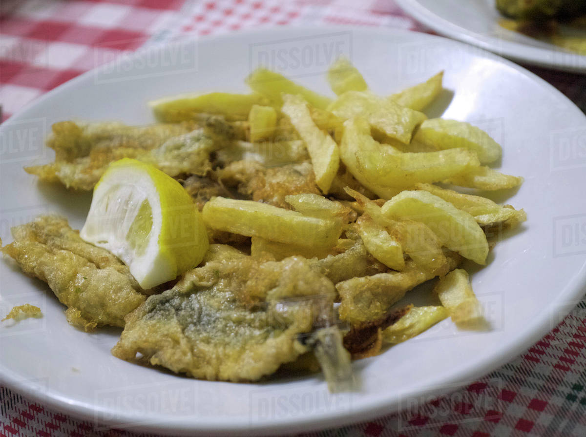 Plate of fried fish and french fries with lemon - Stock Photo - Dissolve
