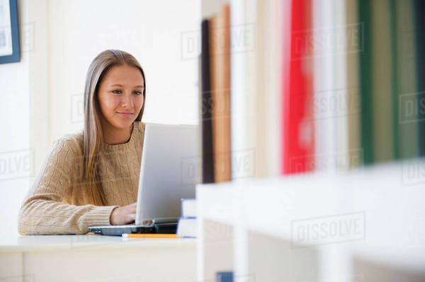 Caucasian teenage girl using laptop at desk - Royalty-free Stock Photo ...