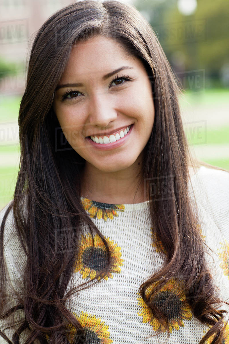 Smiling Hispanic woman standing outdoors - Stock Photo - Dissolve