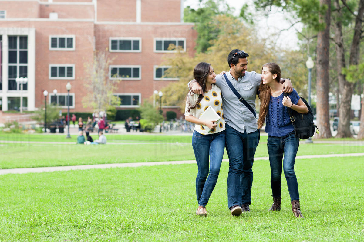 Smiling students walking on campus - Stock Photo - Dissolve