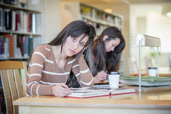 Students working at desk in library - Stock Photo - Dissolve