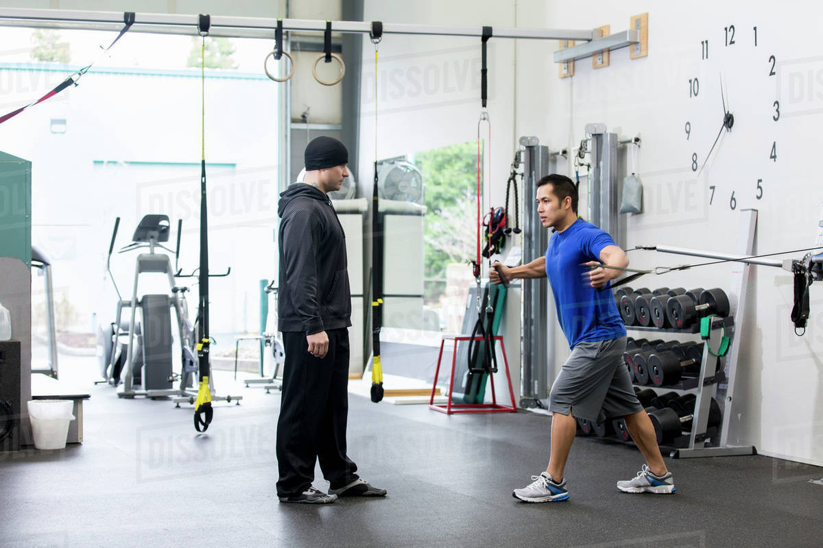Man working with trainer in gym - Royalty-free Stock Photo | Dissolve