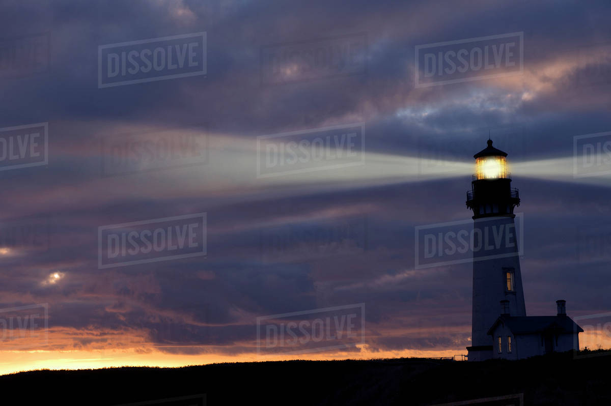 Lighthouse shining against cloudy sky - Royalty-free Stock Photo | Dissolve