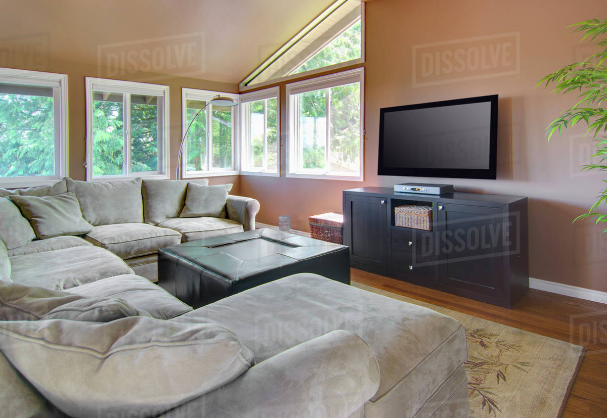 Sectional sofa facing flat screen television in empty living room ...