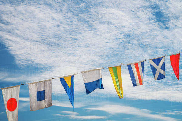 Flags flying against blue sky - Royalty-free Stock Photo | Dissolve