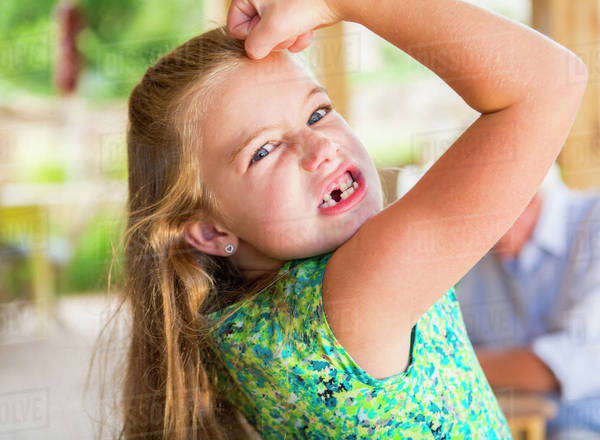 Caucasian girl showing missing teeth and flexing biceps - Royalty-free ...