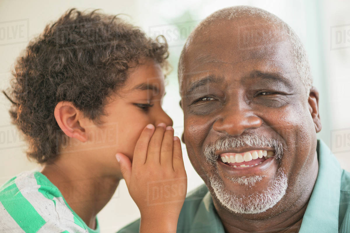 Boy whispering in grandfather's ear - Royalty-free Stock Photo | Dissolve
