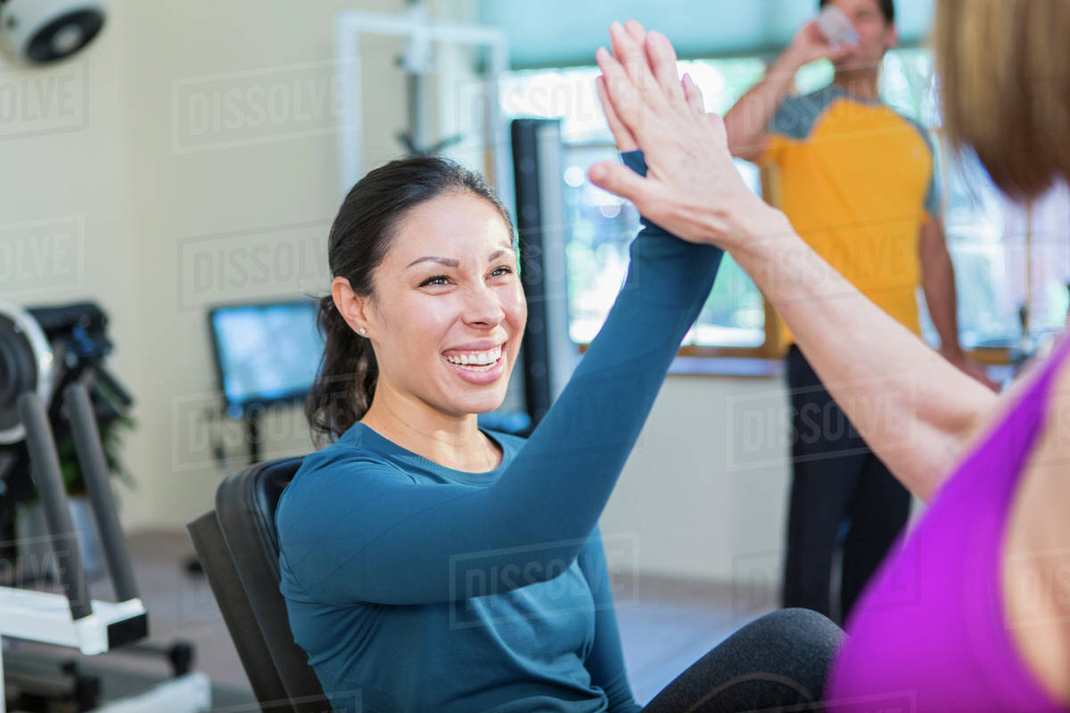 Women high-fiving in gym - Royalty-free Stock Photo | Dissolve