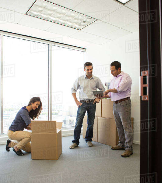 Business people unpacking in new office - Stock Photo - Dissolve