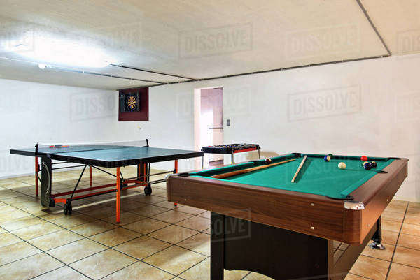 Pool table and ping pong table in basement - Stock Photo - Dissolve