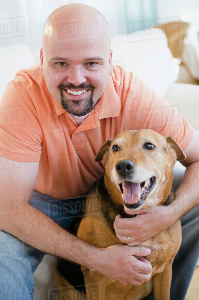 Smiling man hugging dog - Royalty-free Stock Photo | Dissolve