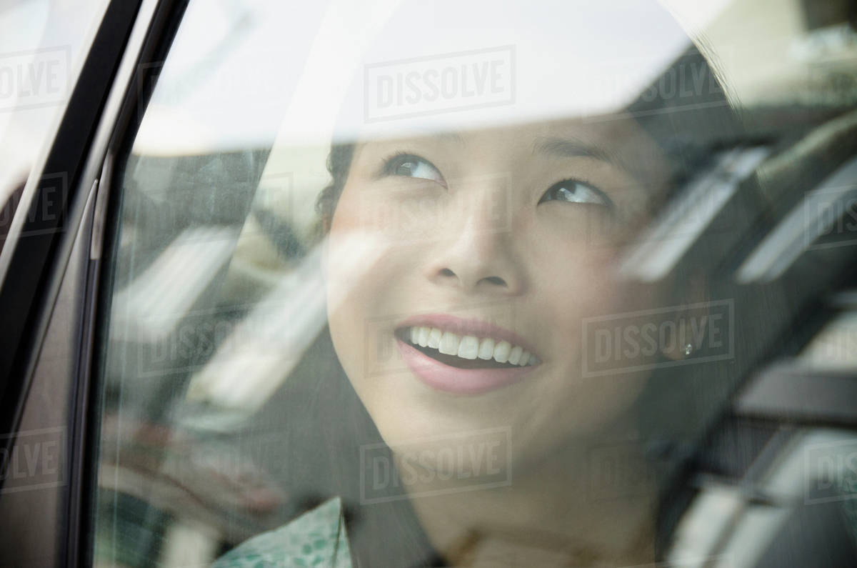 Asian woman riding in car - Stock Photo - Dissolve
