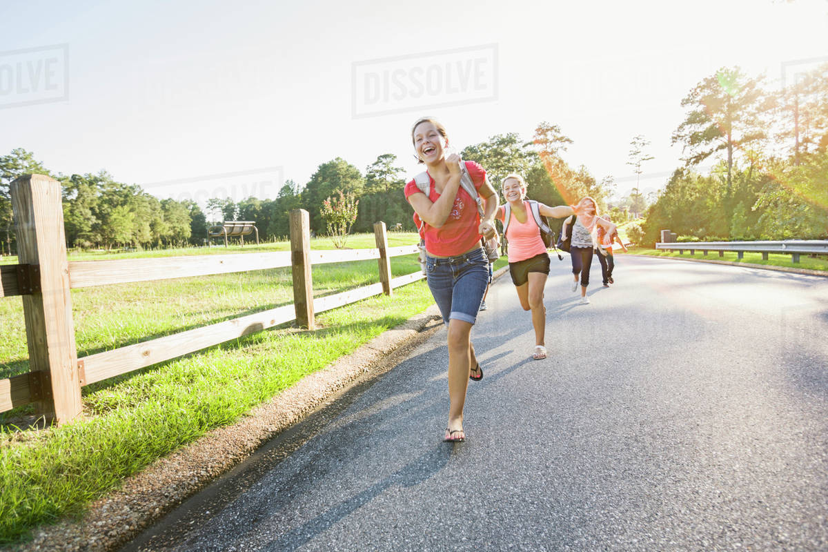 Caucasian girls running on road - Royalty-free Stock Photo | Dissolve