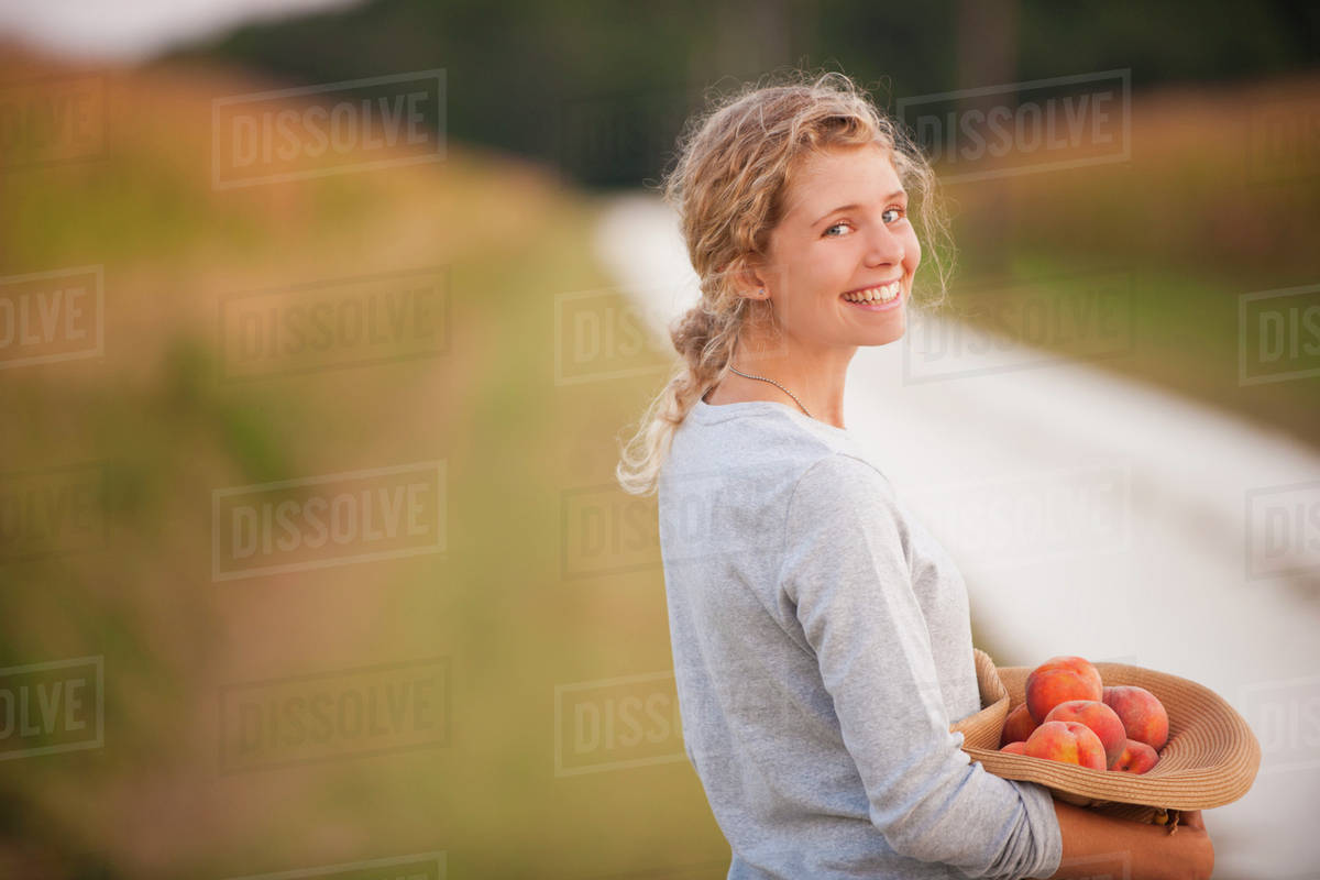 Caucasian woman picking fruit on rural road - Stock Photo - Dissolve